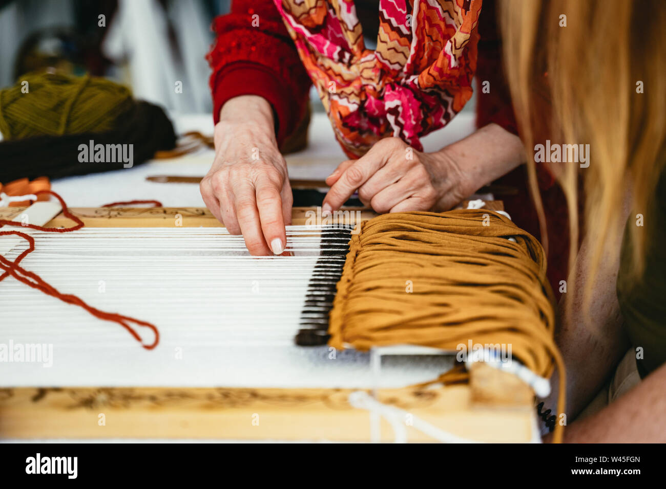 Woman demonstrating weaving on a hand loom Stock Photo - Alamy