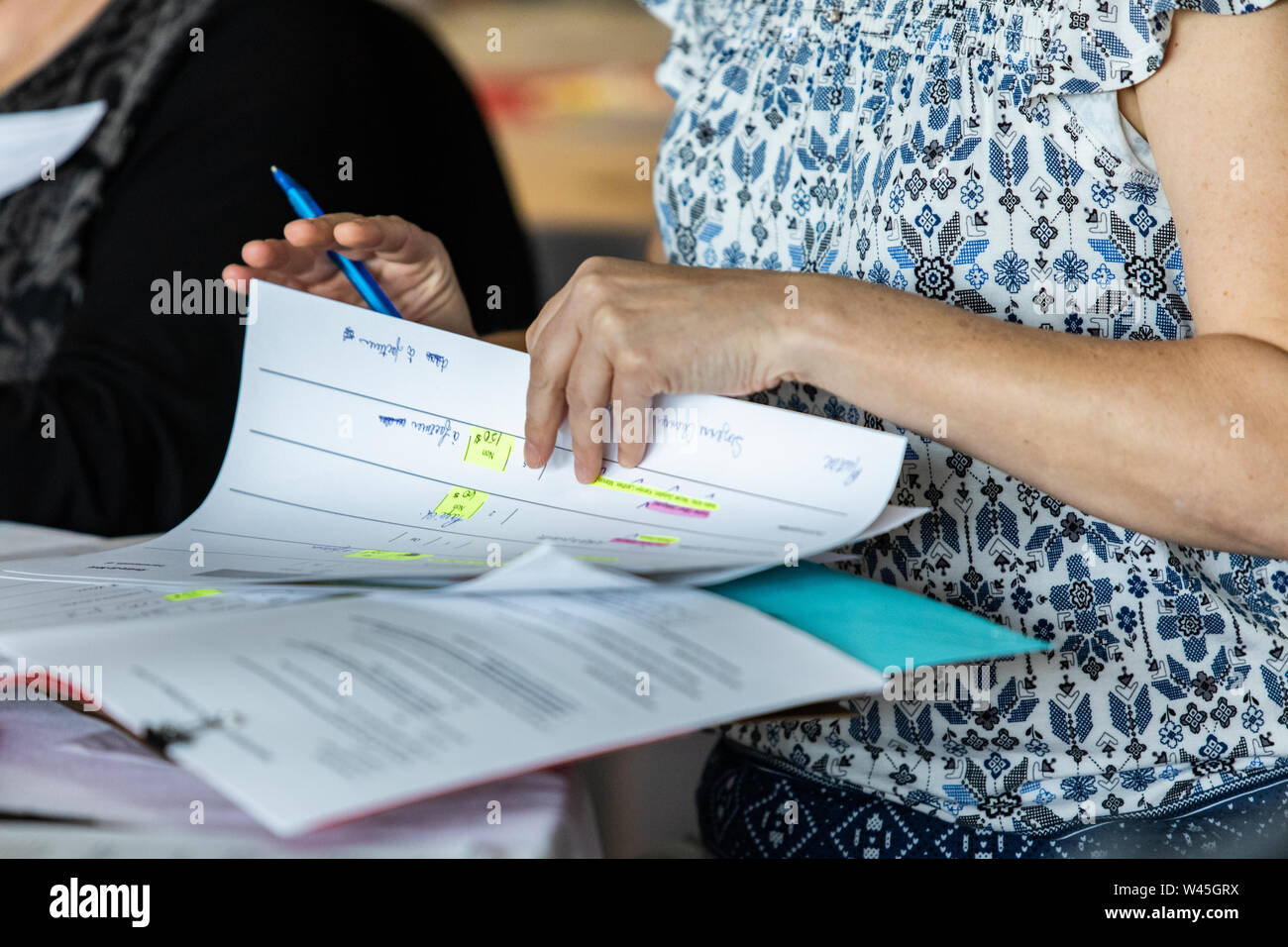 A close up view on a professional woman reading paperwork, she uses ...