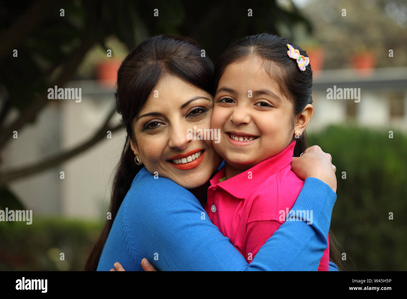 Portrait of a woman hugging her daughter Stock Photo - Alamy