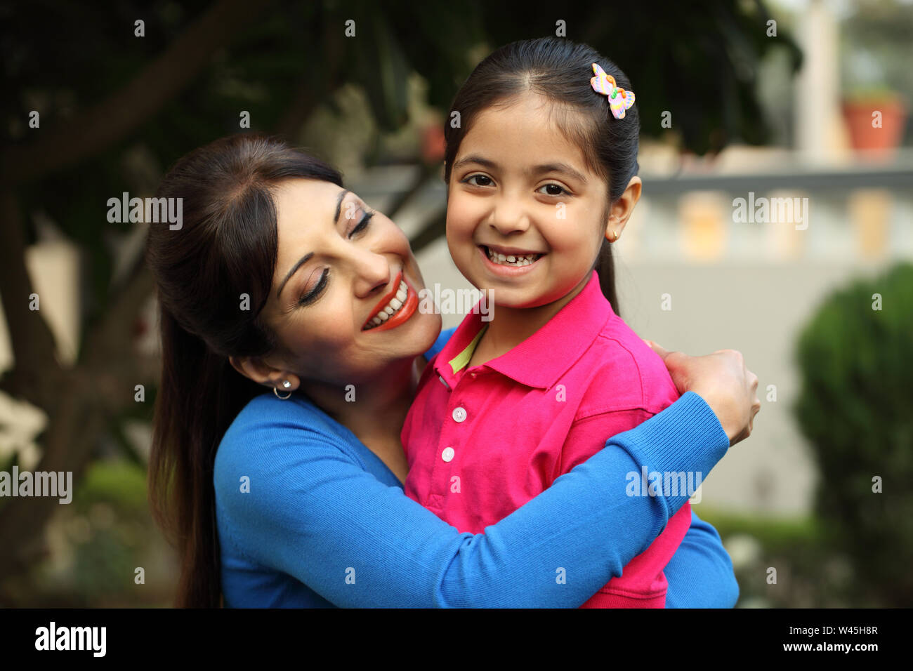 Woman hugging her daughter and smiling Stock Photo - Alamy
