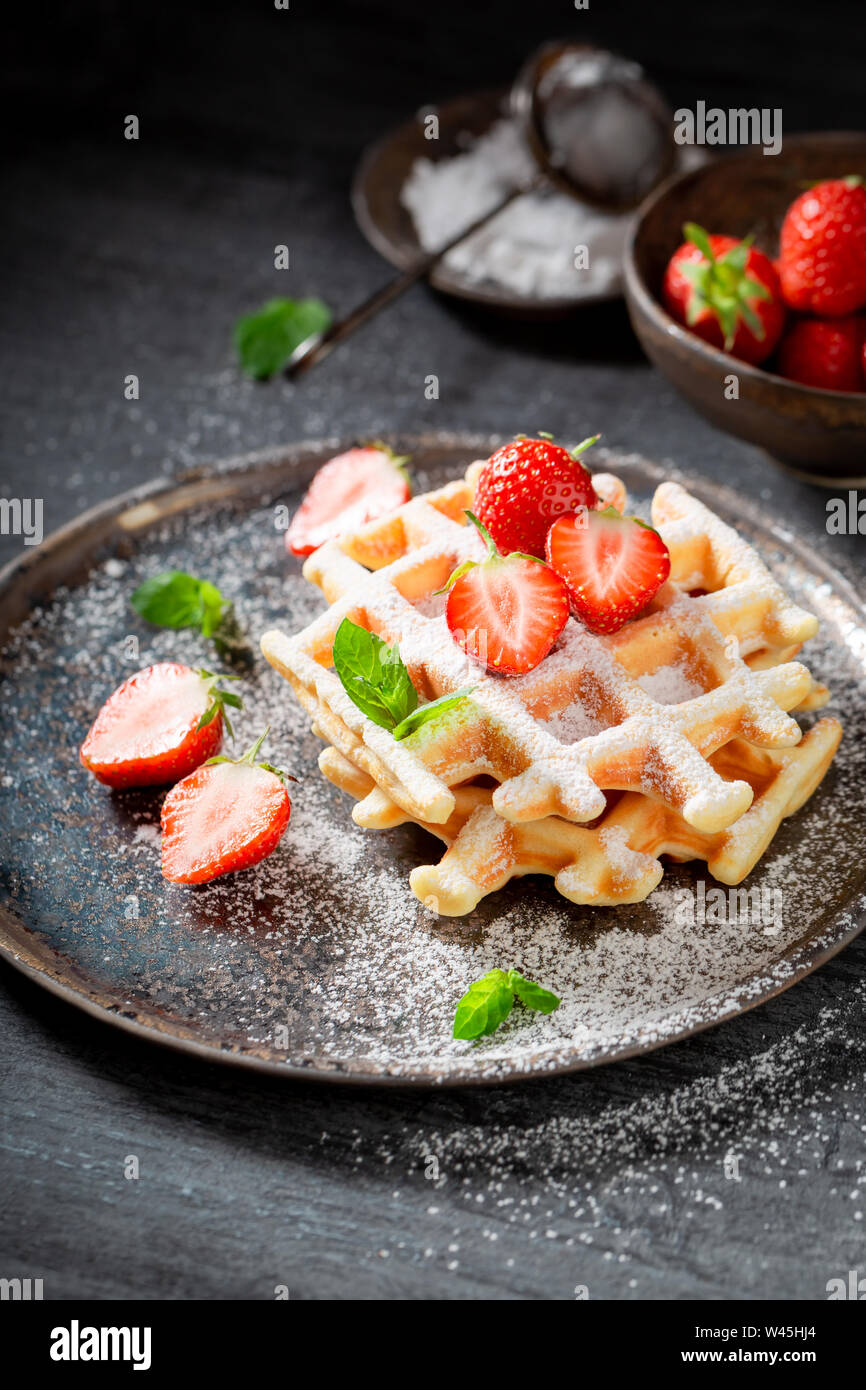 Delicious wafers with powdered sugar and sweet fruits Stock Photo - Alamy