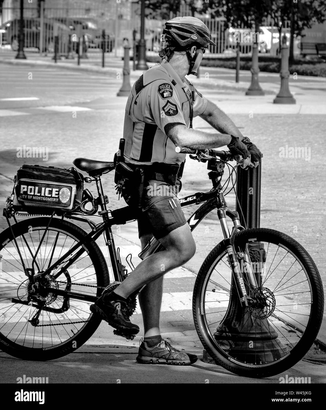 A bicycle policeman on duty rest with his bike on the streets of ...