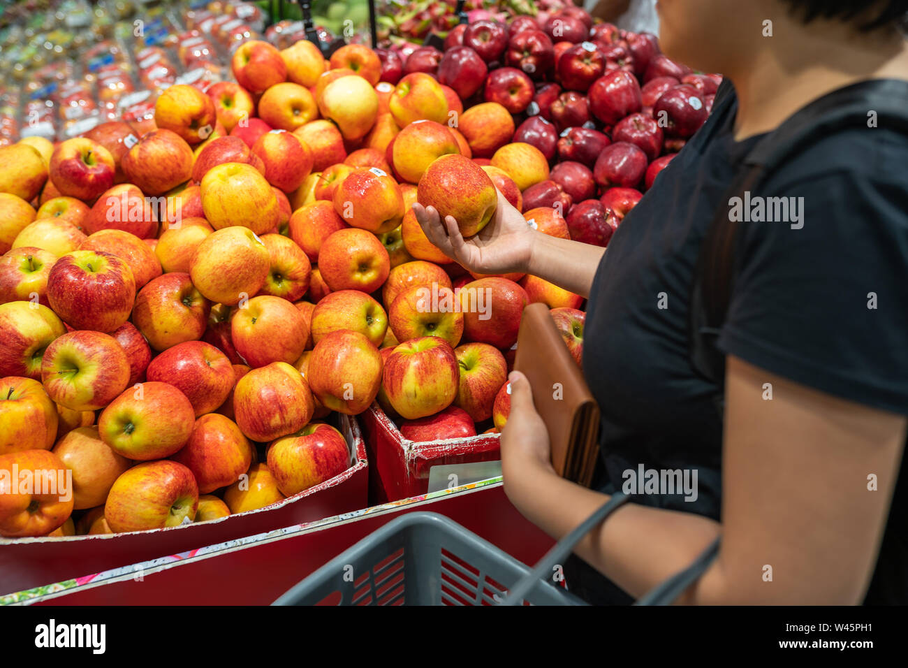 Asian woman picking apple at fruit stand in supermarket Stock Photo - Alamy