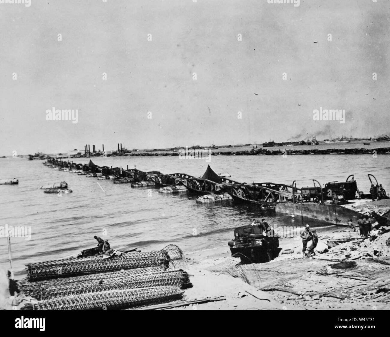 Construction of Mulberry harbor bridges following landing, Normandy ...
