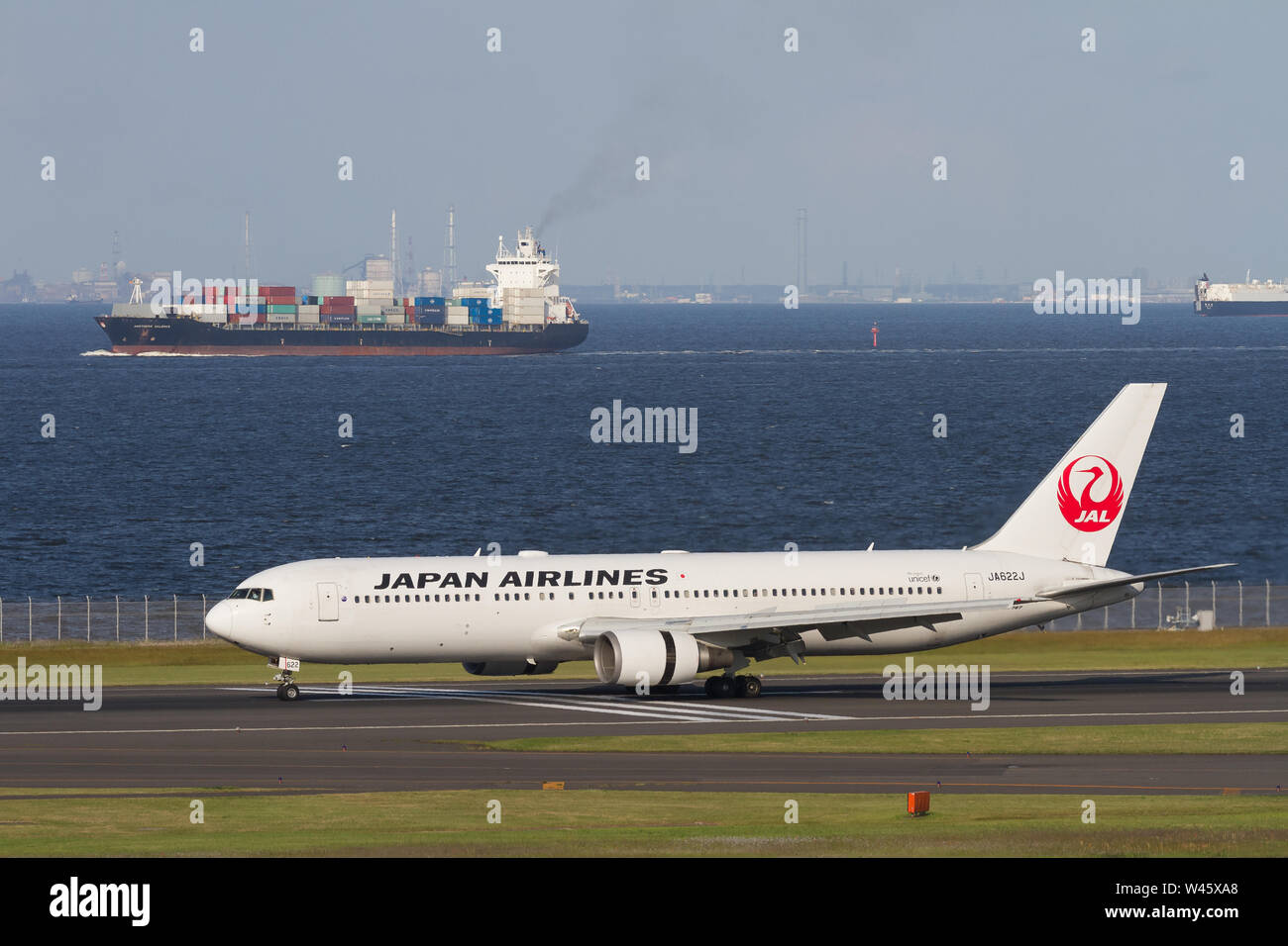 A Japan Airlines (JAL) Boeing 767-346(ERJ in front of a large cargo ...