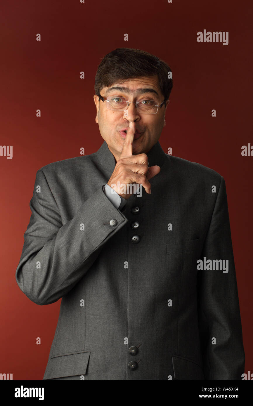 Portrait of a man with a finger on lips Stock Photo - Alamy