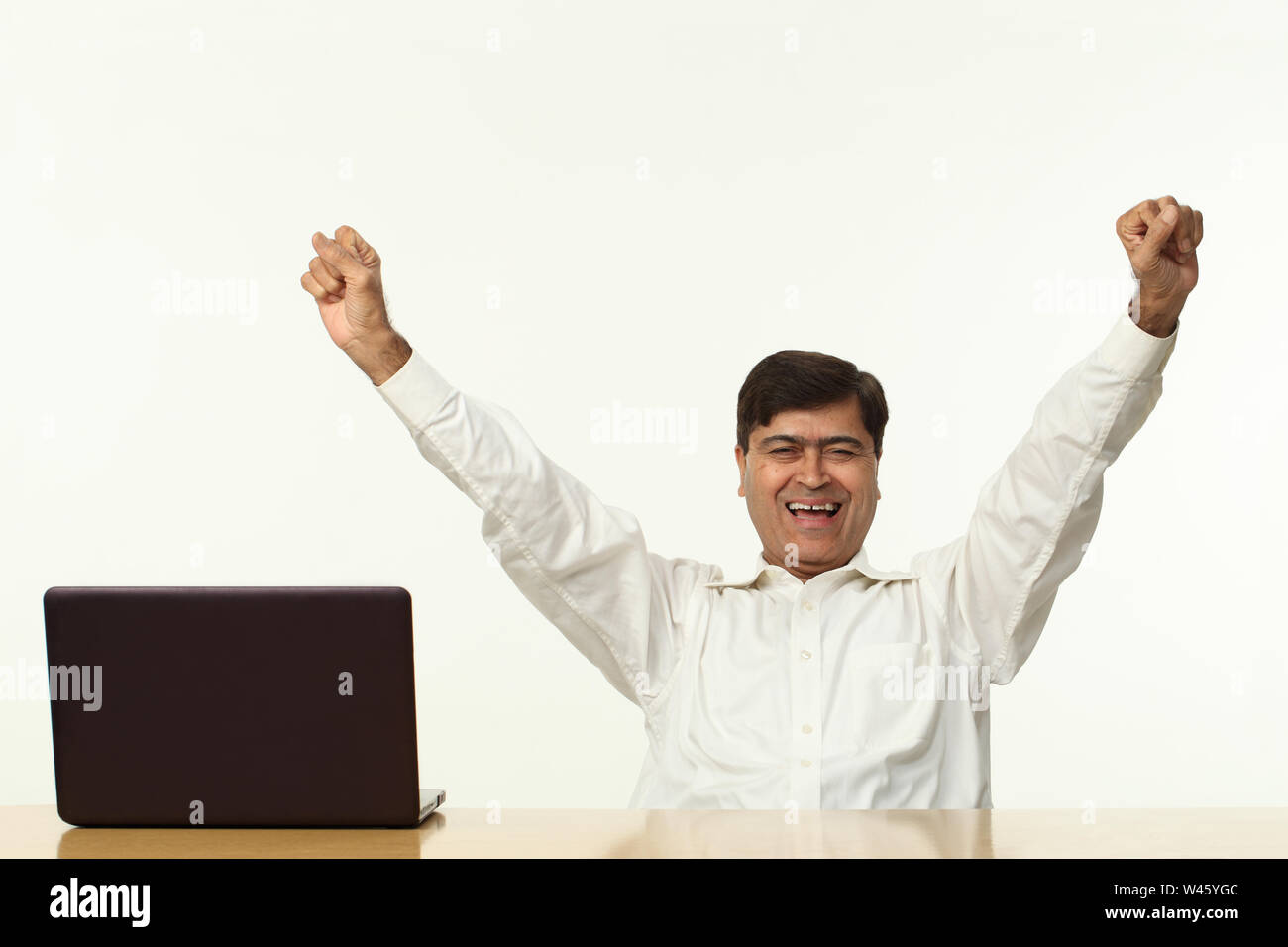 Businessman laughing with arms raised Stock Photo - Alamy
