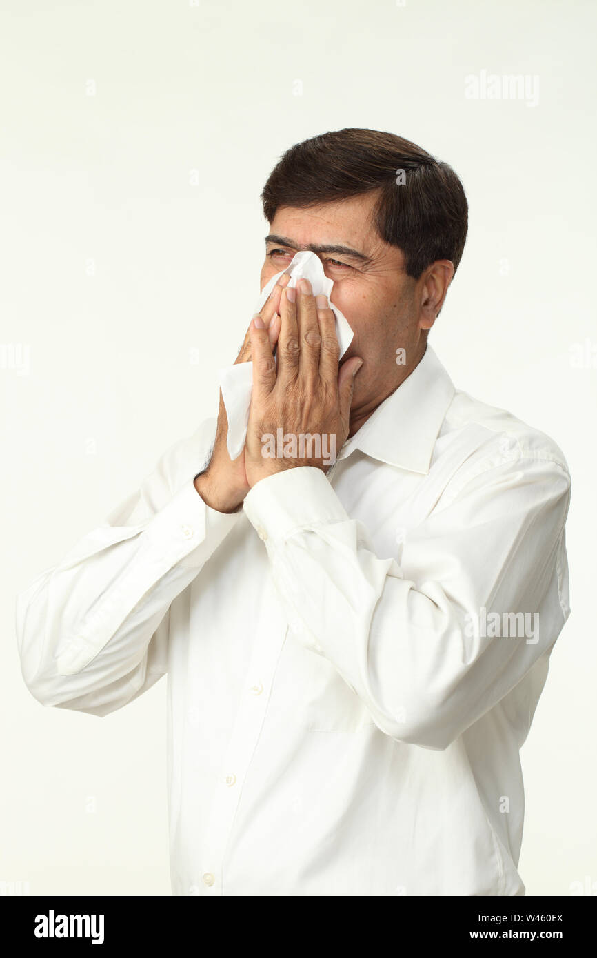 Businessman blowing nose with tissue paper Stock Photo - Alamy