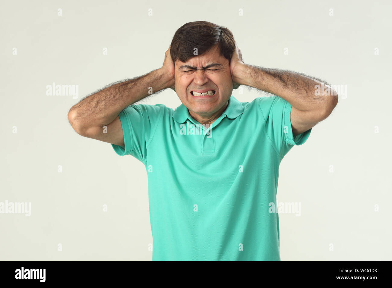Man covering ears with hands Stock Photo - Alamy