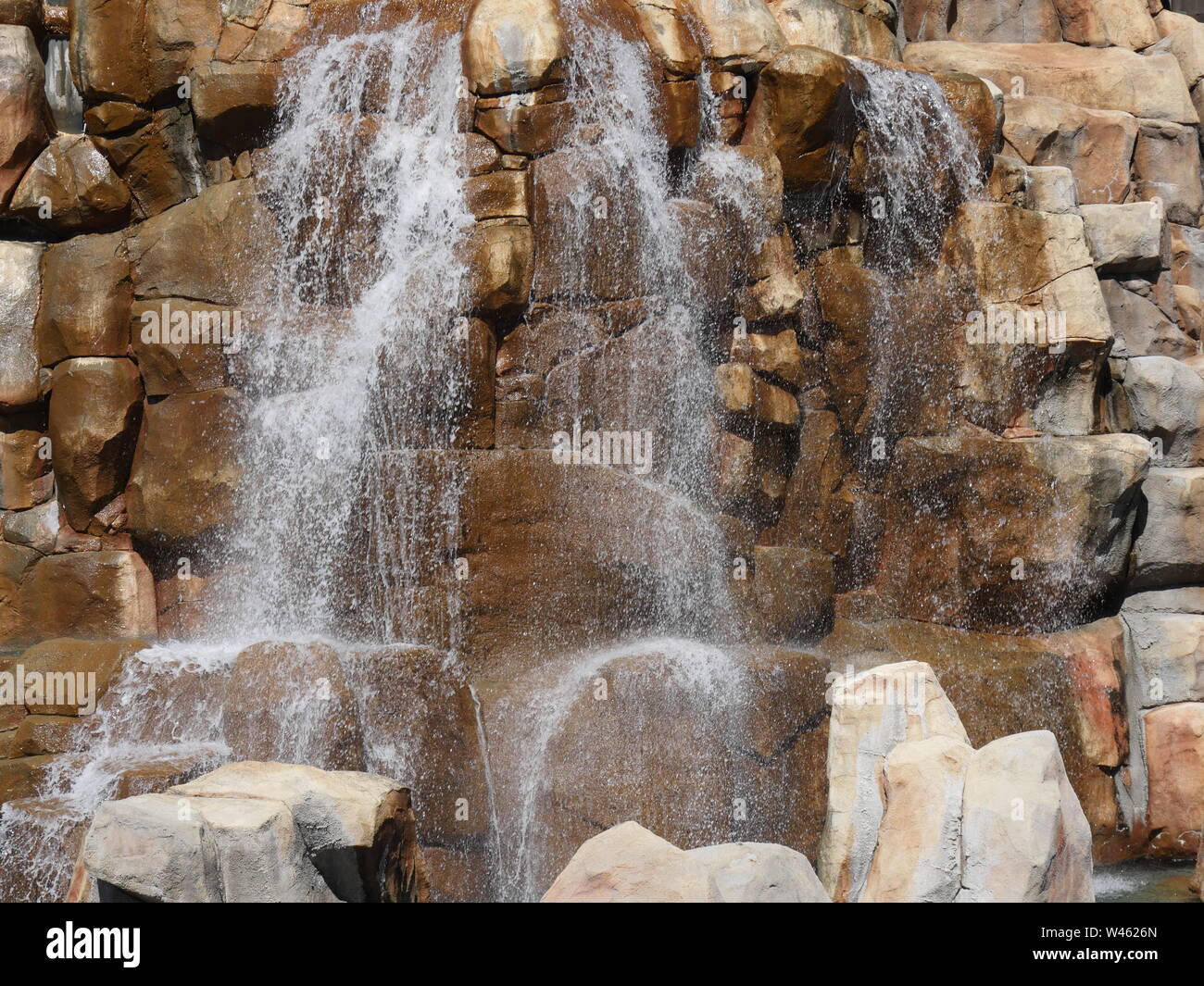 Close up of water falling down rocks in a landscaped garden Stock Photo ...