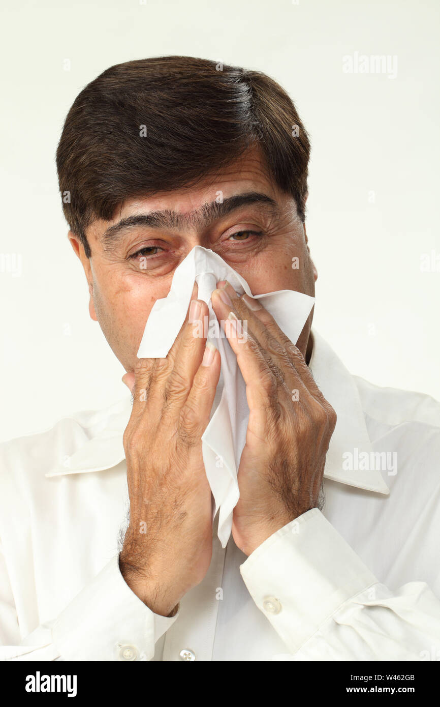 Man blowing nose with tissue paper Stock Photo - Alamy