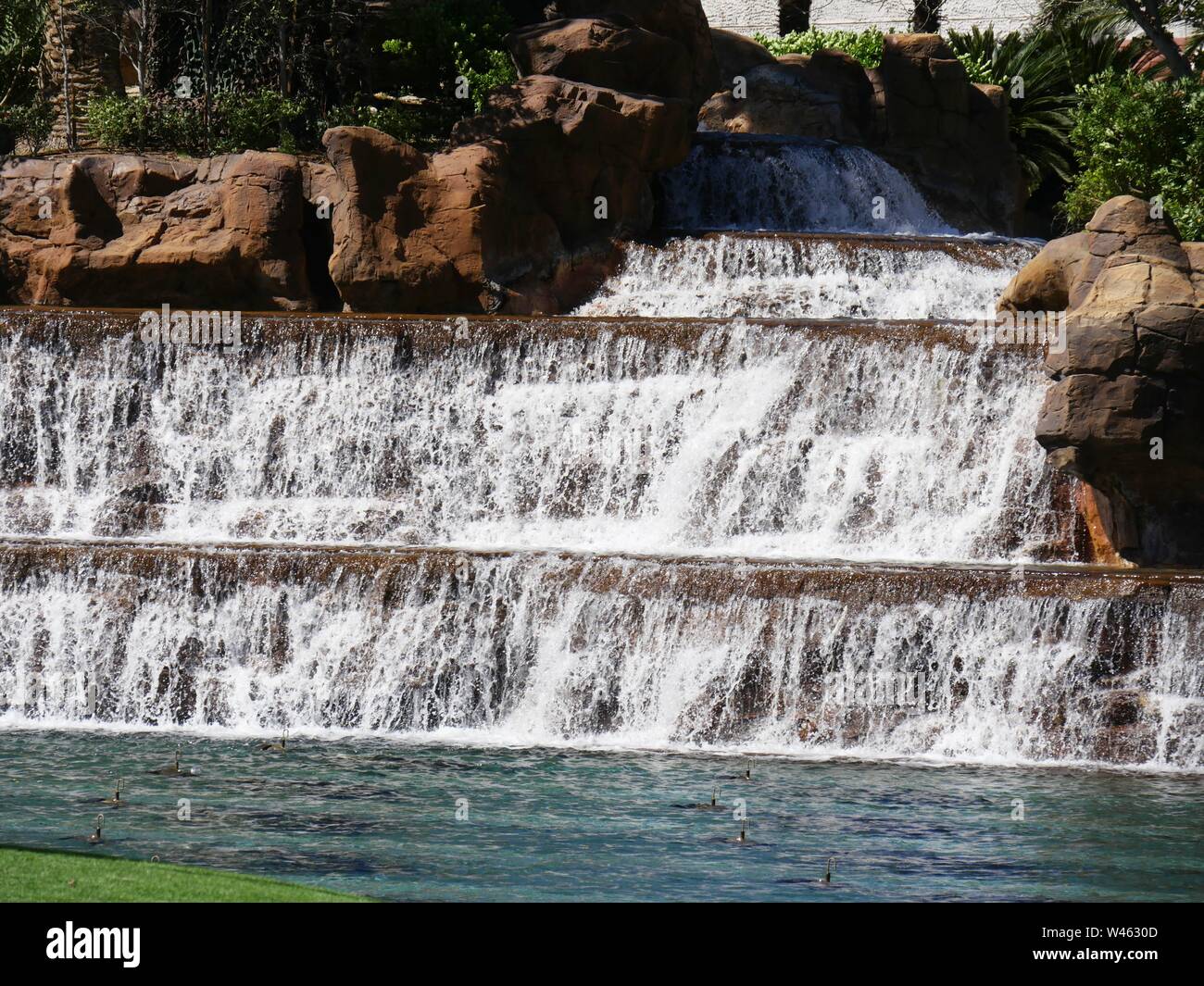 Close up of water cascading down a waterfalls in a landscaped garden ...