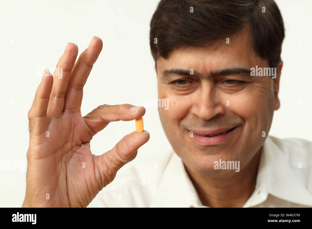 Man holding a pill Stock Photo - Alamy