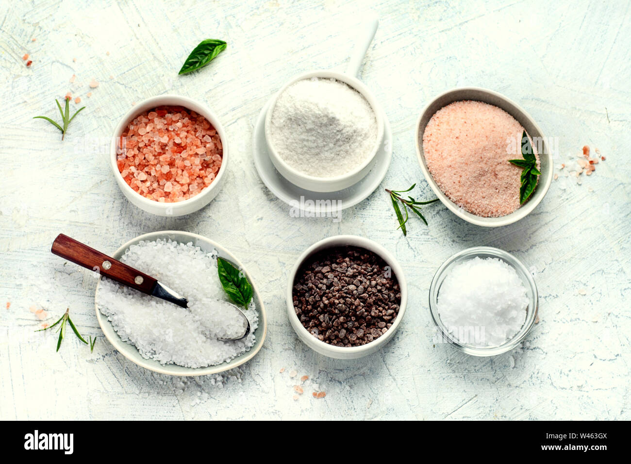 Different salt types on grey background. Top view Stock Photo - Alamy