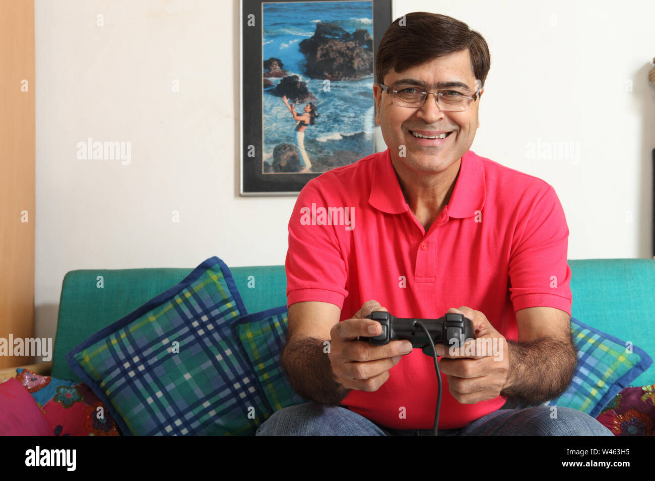 Man playing video game and smiling Stock Photo - Alamy