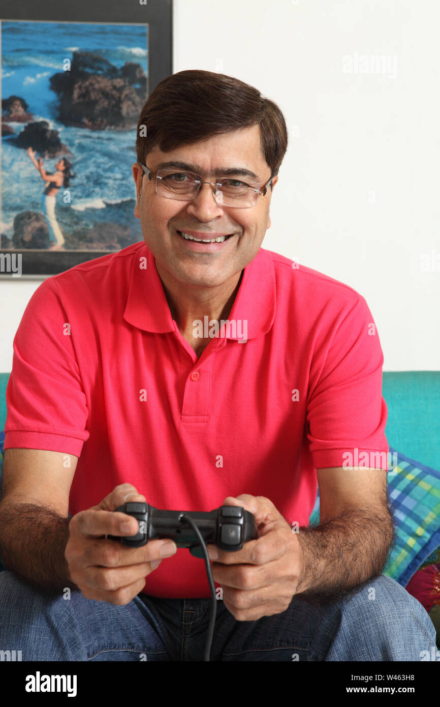 Man playing video game and smiling Stock Photo - Alamy