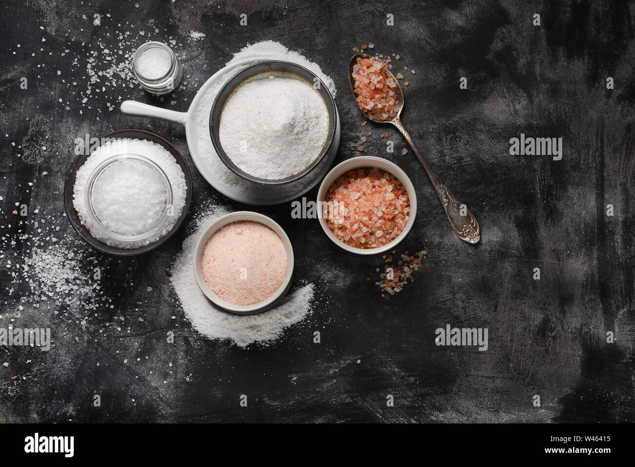 Different types of salt on black background. Top view with copy space ...