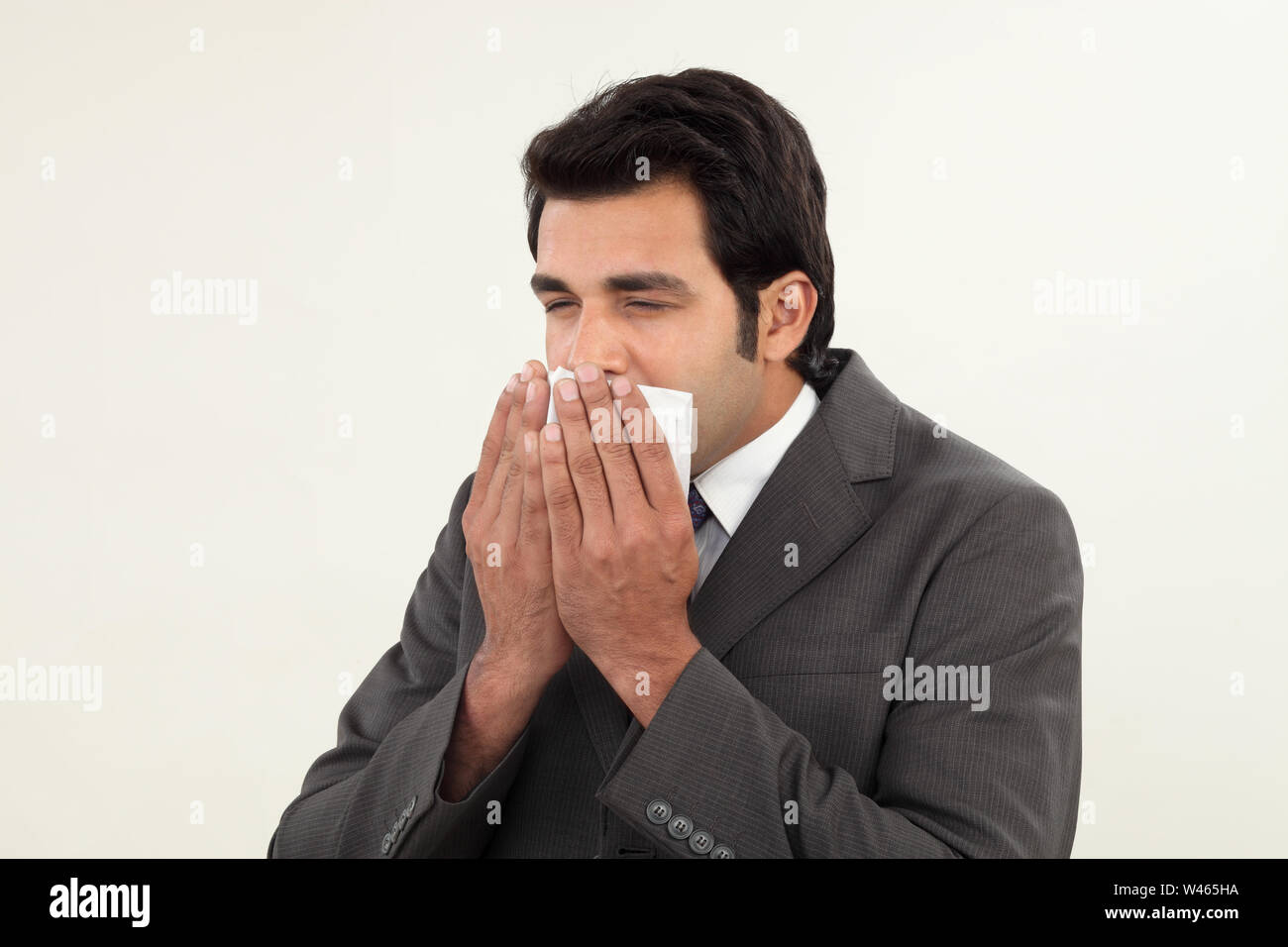Businessman blowing nose with tissue paper Stock Photo - Alamy