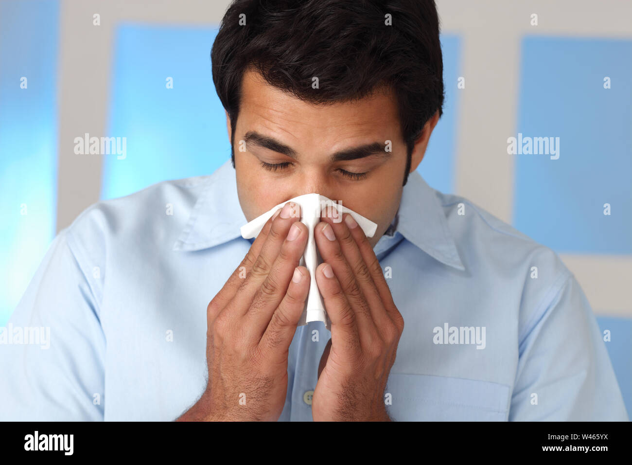 Man blowing nose with tissue paper Stock Photo - Alamy