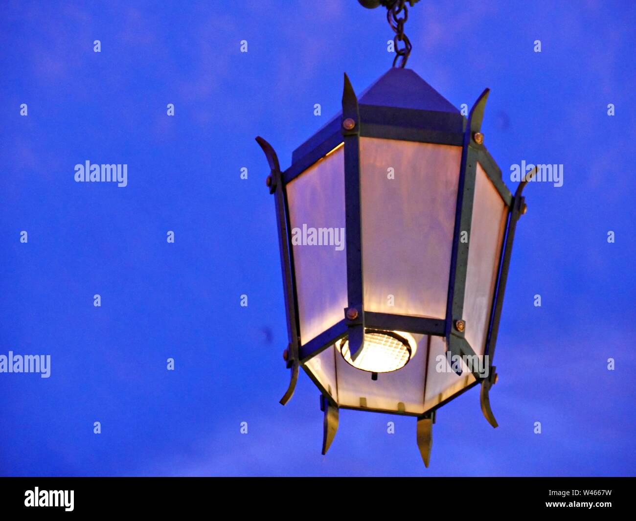 Close upward shot of a lighted lamp post, with blue background Stock ...