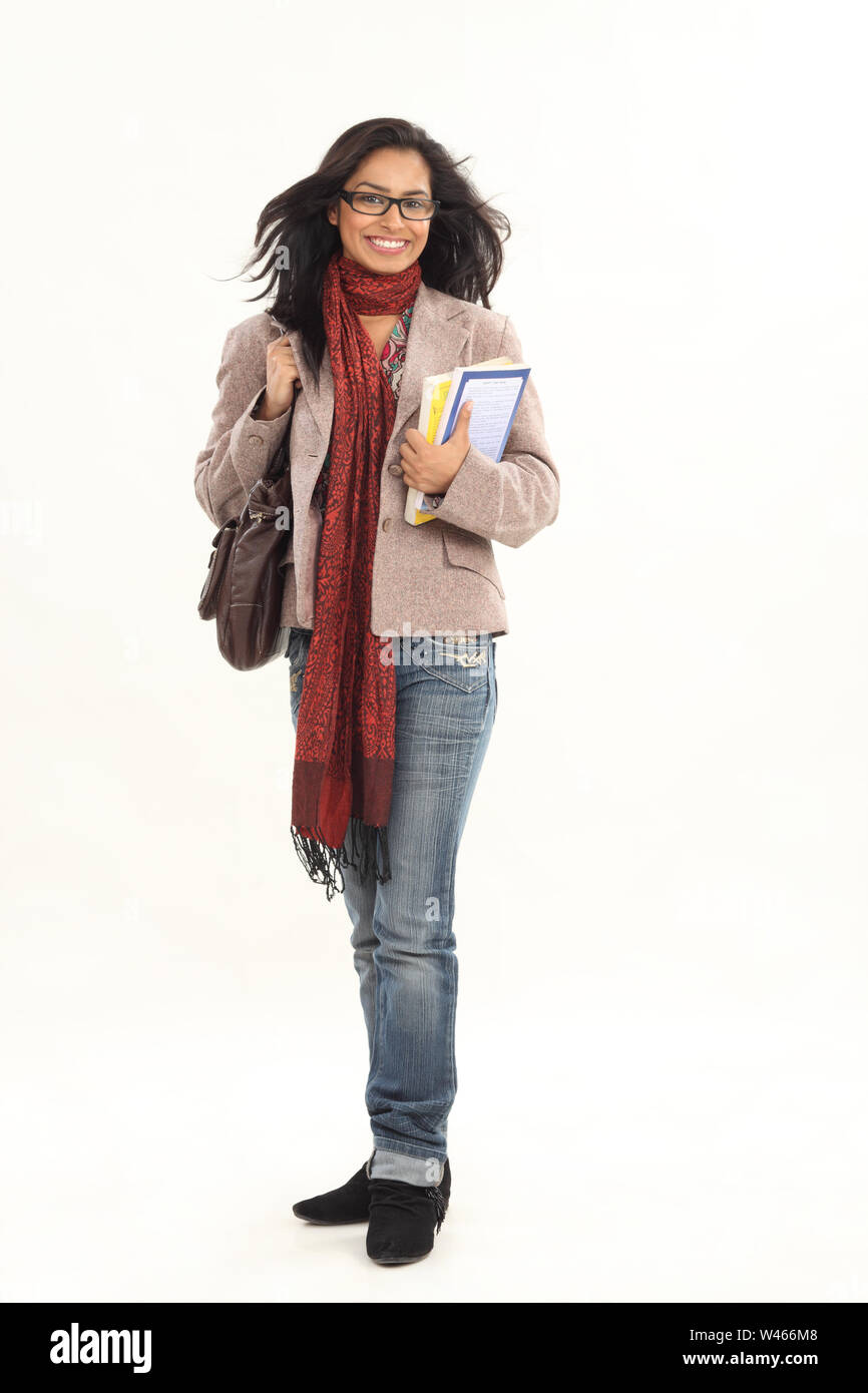 College student holding books and smiling Stock Photo - Alamy
