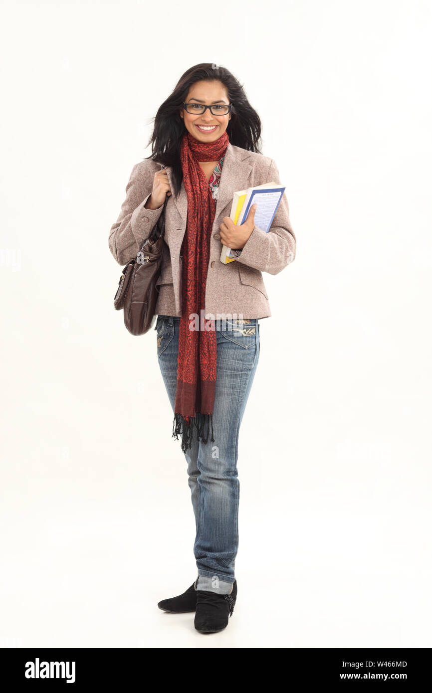 College student holding books and smiling Stock Photo - Alamy