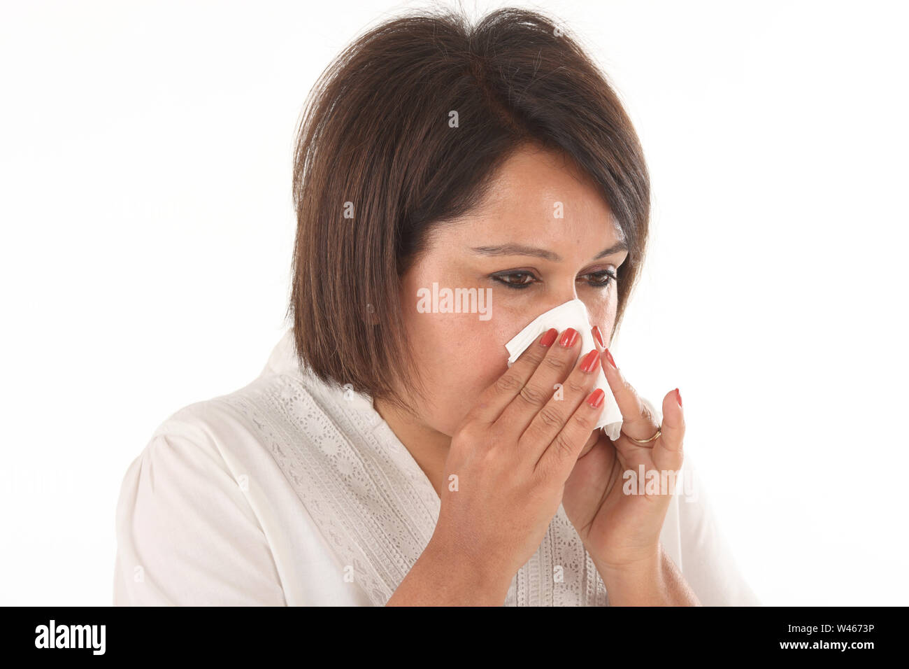 Woman blowing nose with tissue paper Stock Photo - Alamy