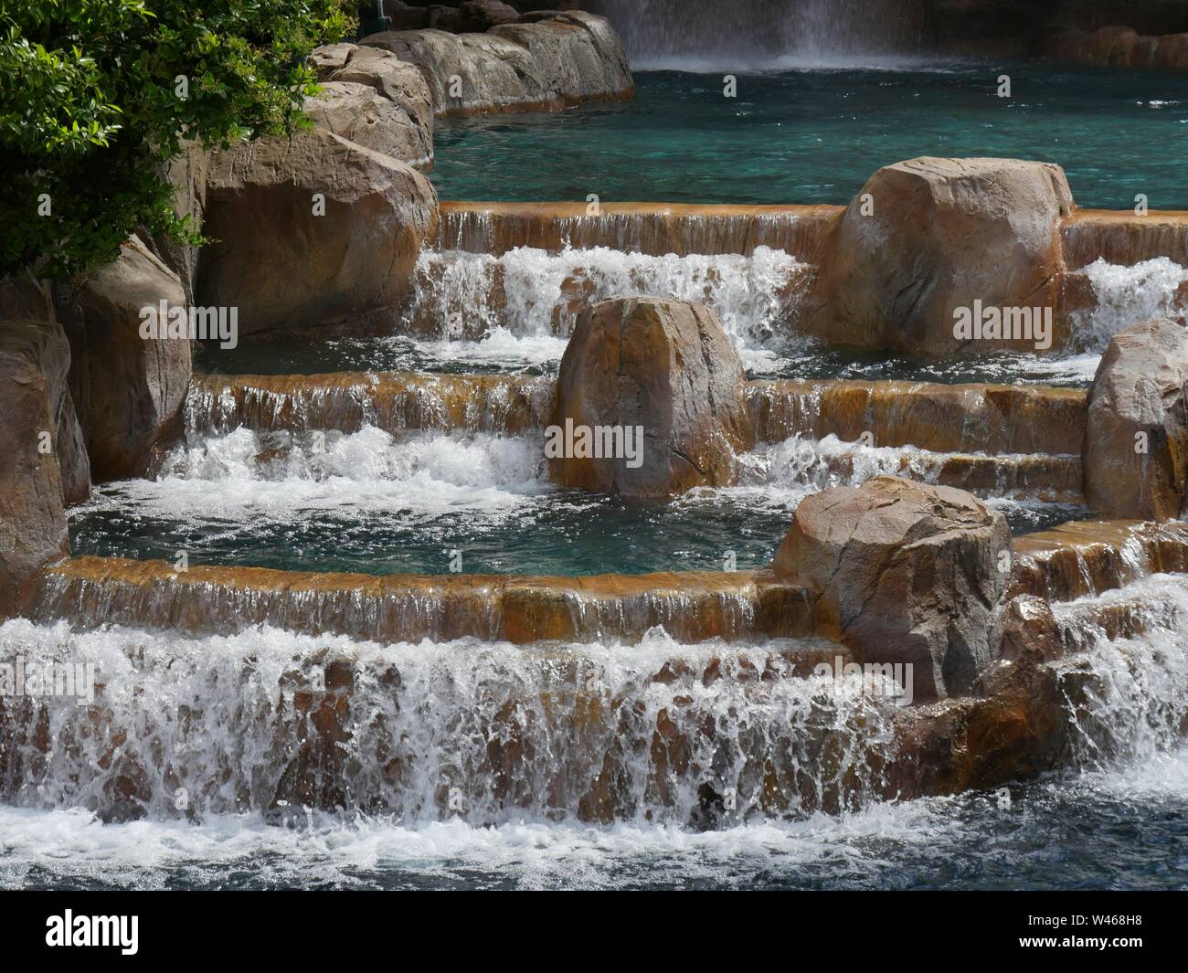 Foaming water rippling down waterfalls in a landscaped garden Stock ...