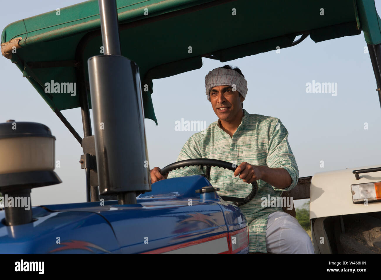 Farmer driving a tractor Stock Photo - Alamy