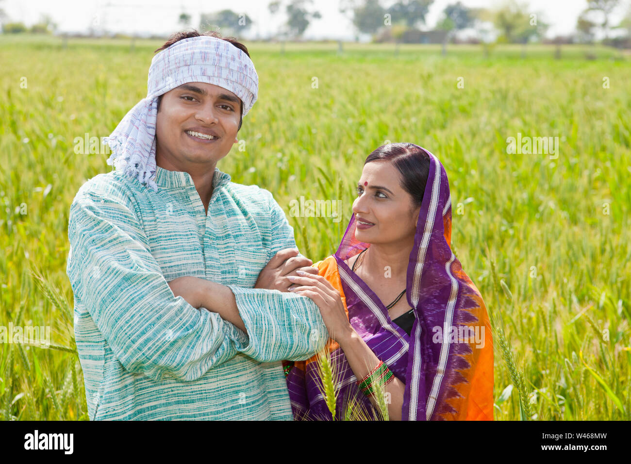 Rural couple standing in a field and smiling Stock Photo - Alamy
