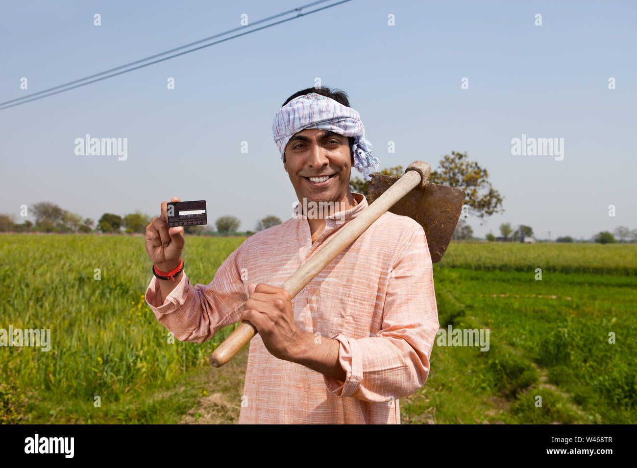Farmer showing a credit card and smiling Stock Photo - Alamy