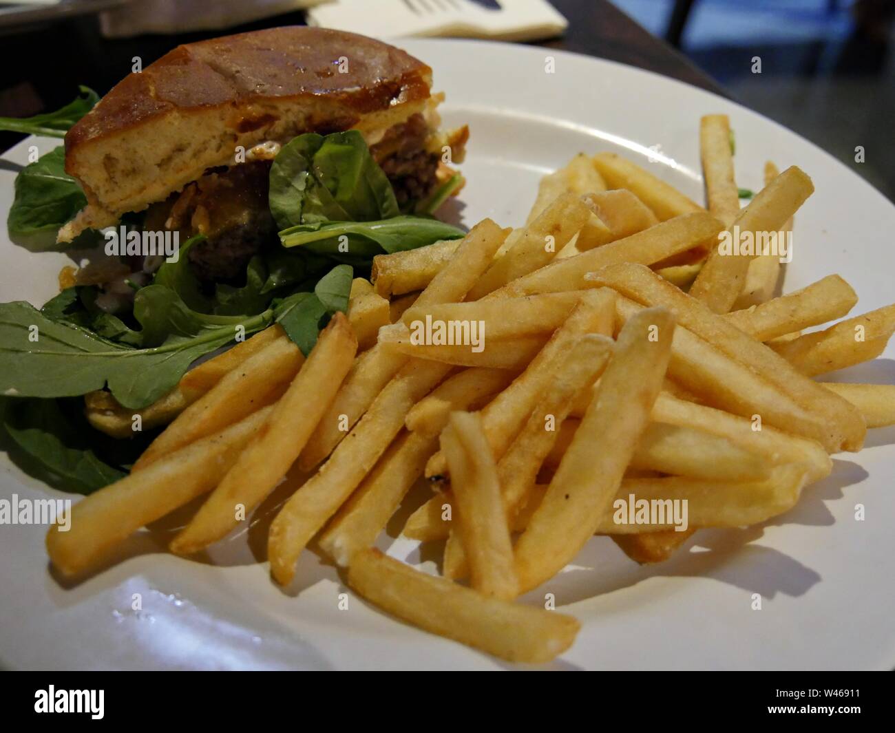 Hamburger, half serving with French fries and vegetable greens Stock ...