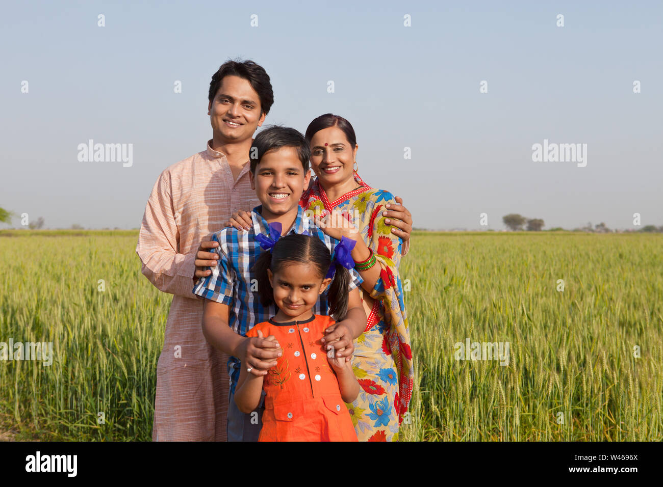 Rural family standing in a field and smiling Stock Photo - Alamy