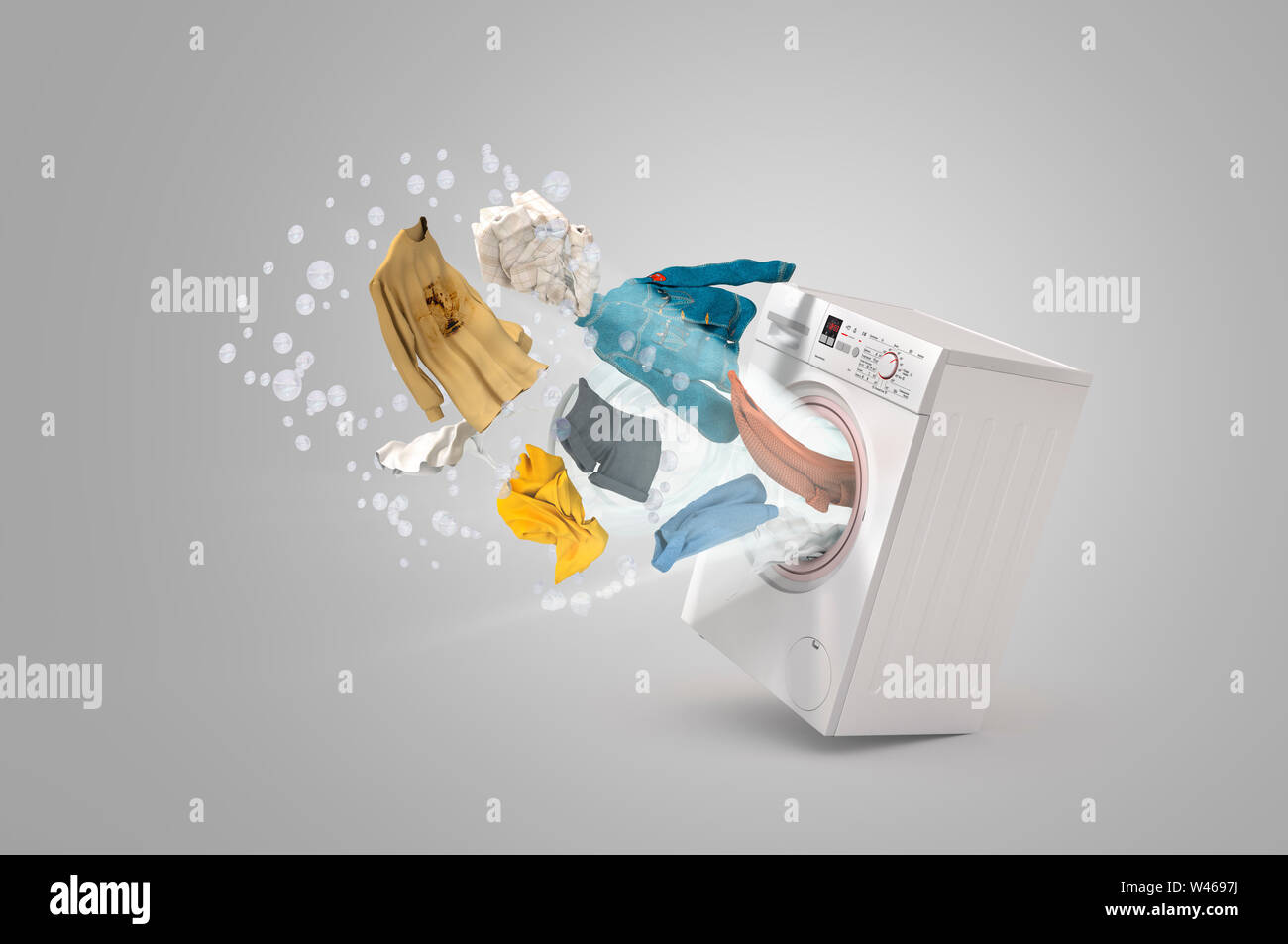 Washing machine and flying clothes on grey background Stock Photo - Alamy