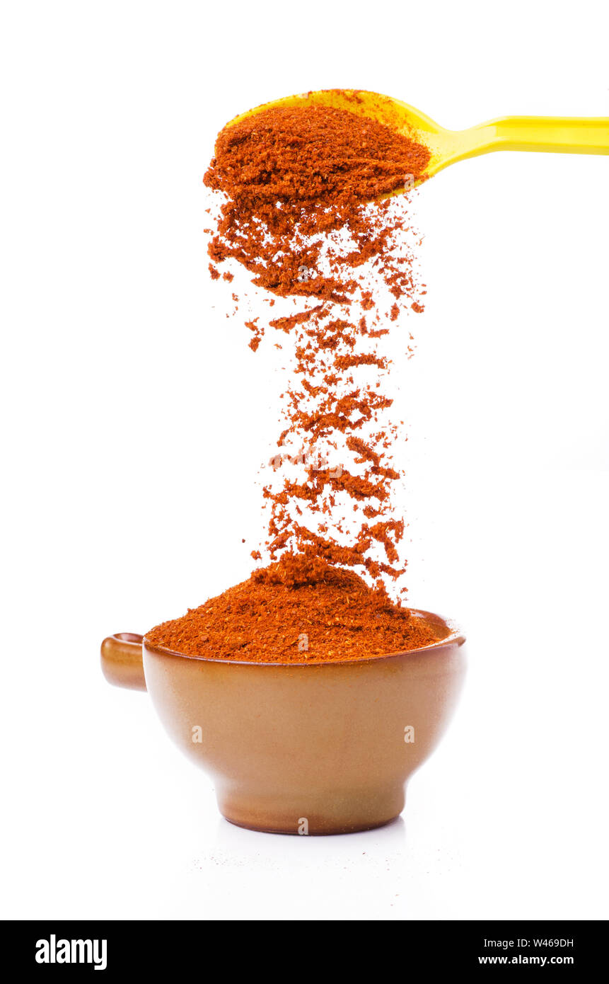 spoon full of spicy chili is poured into bowl isolated from the ...