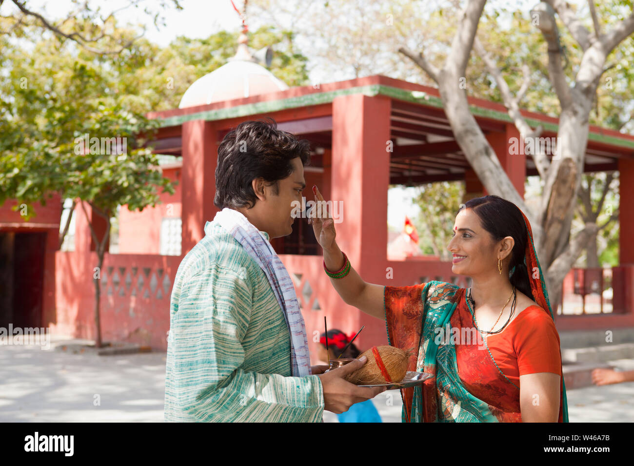 Woman applying tika on her husband forehead Stock Photo - Alamy