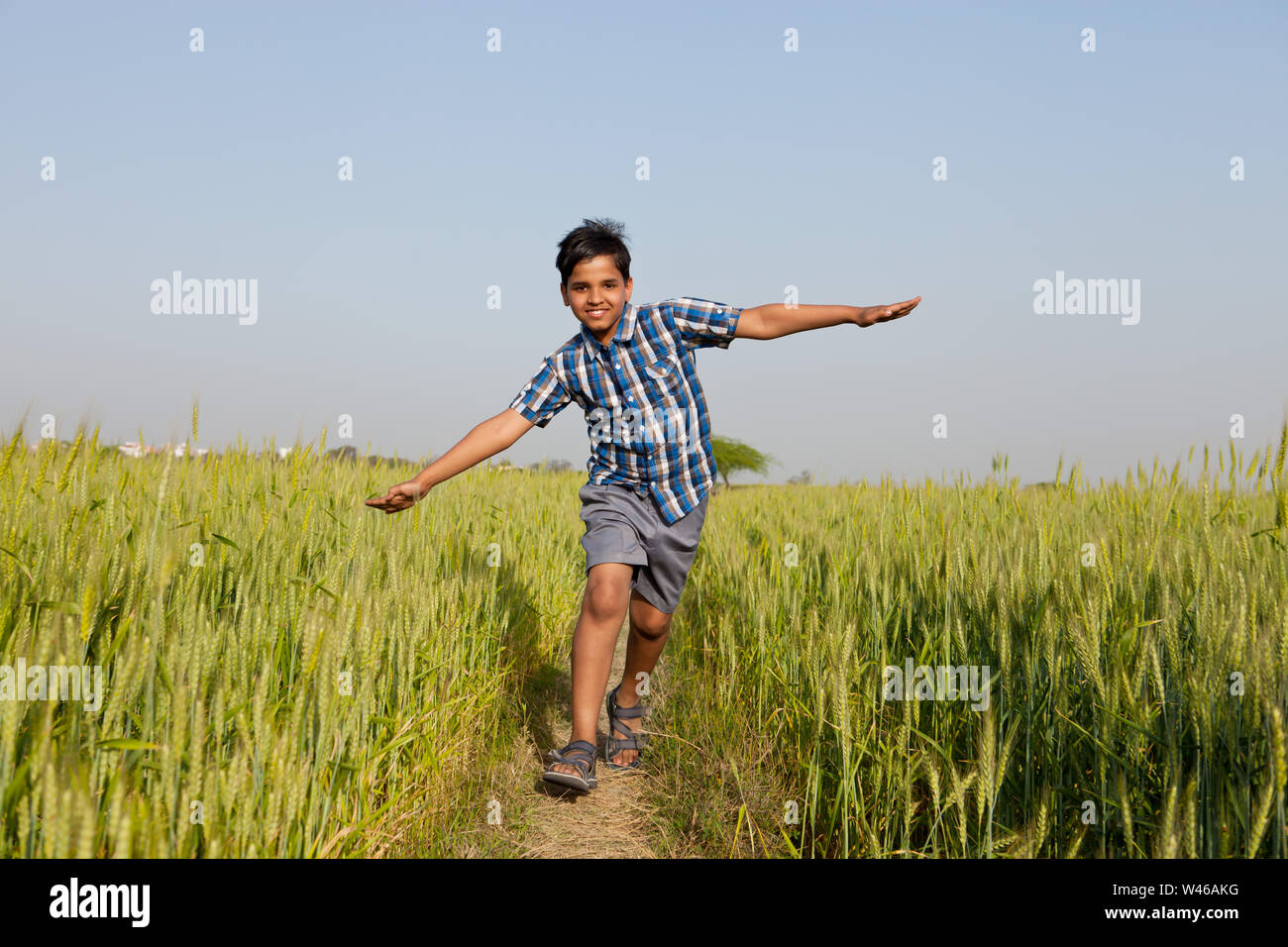Boy running in a field Stock Photo - Alamy