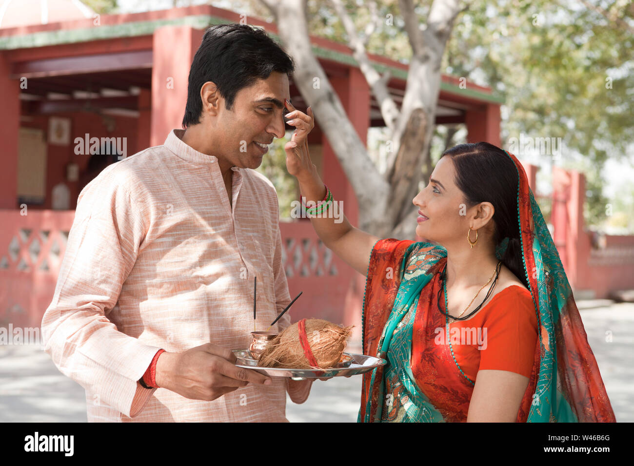 Woman applying tika on her husband forehead Stock Photo - Alamy