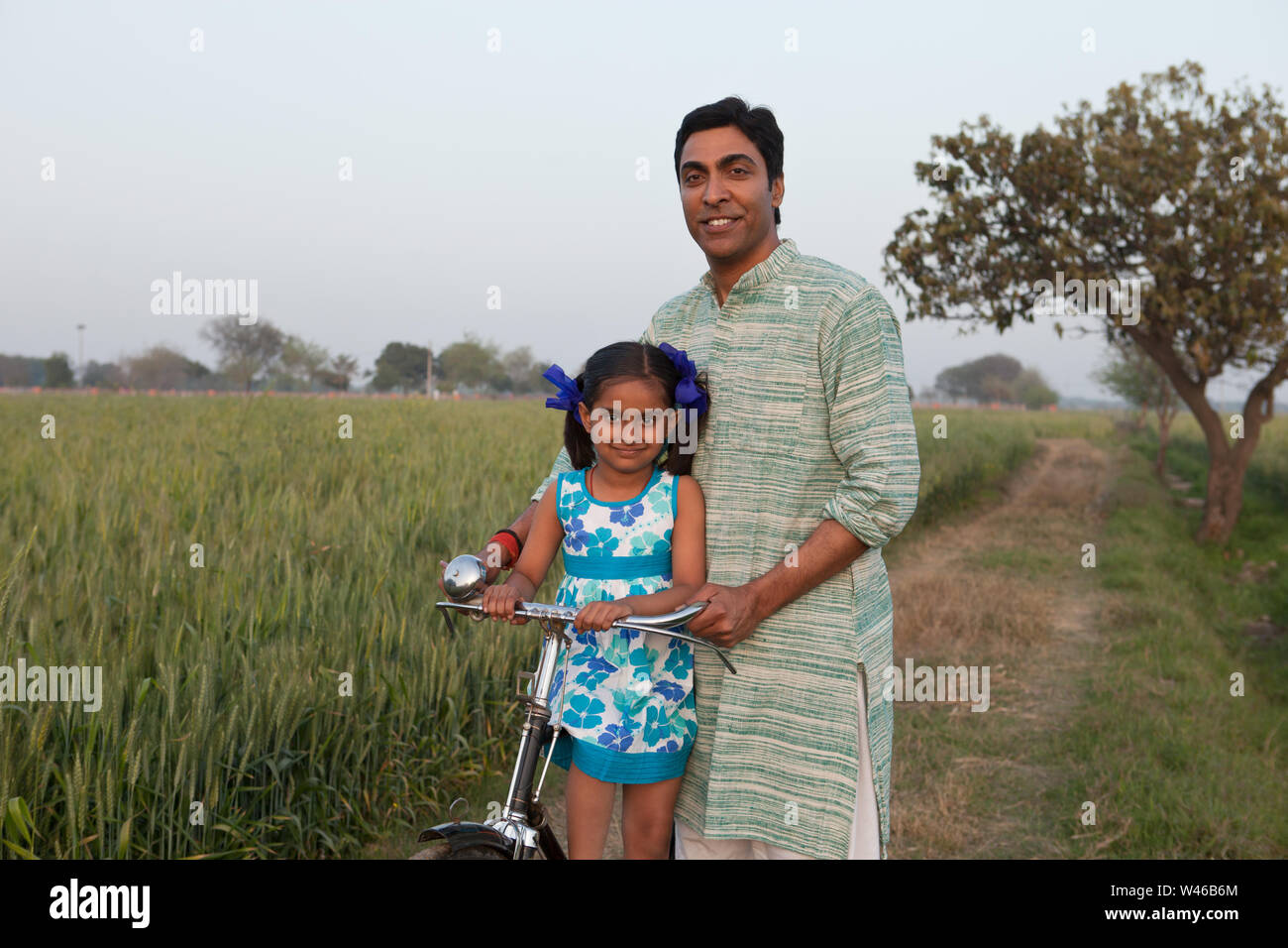 Farmer standing in a field with his daughter Stock Photo - Alamy