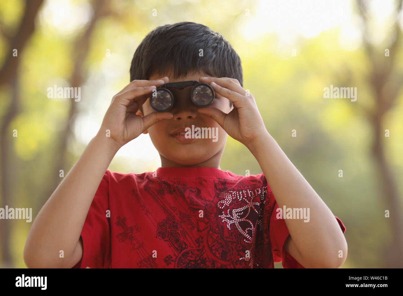 Boy looking through binoculars Stock Photo - Alamy