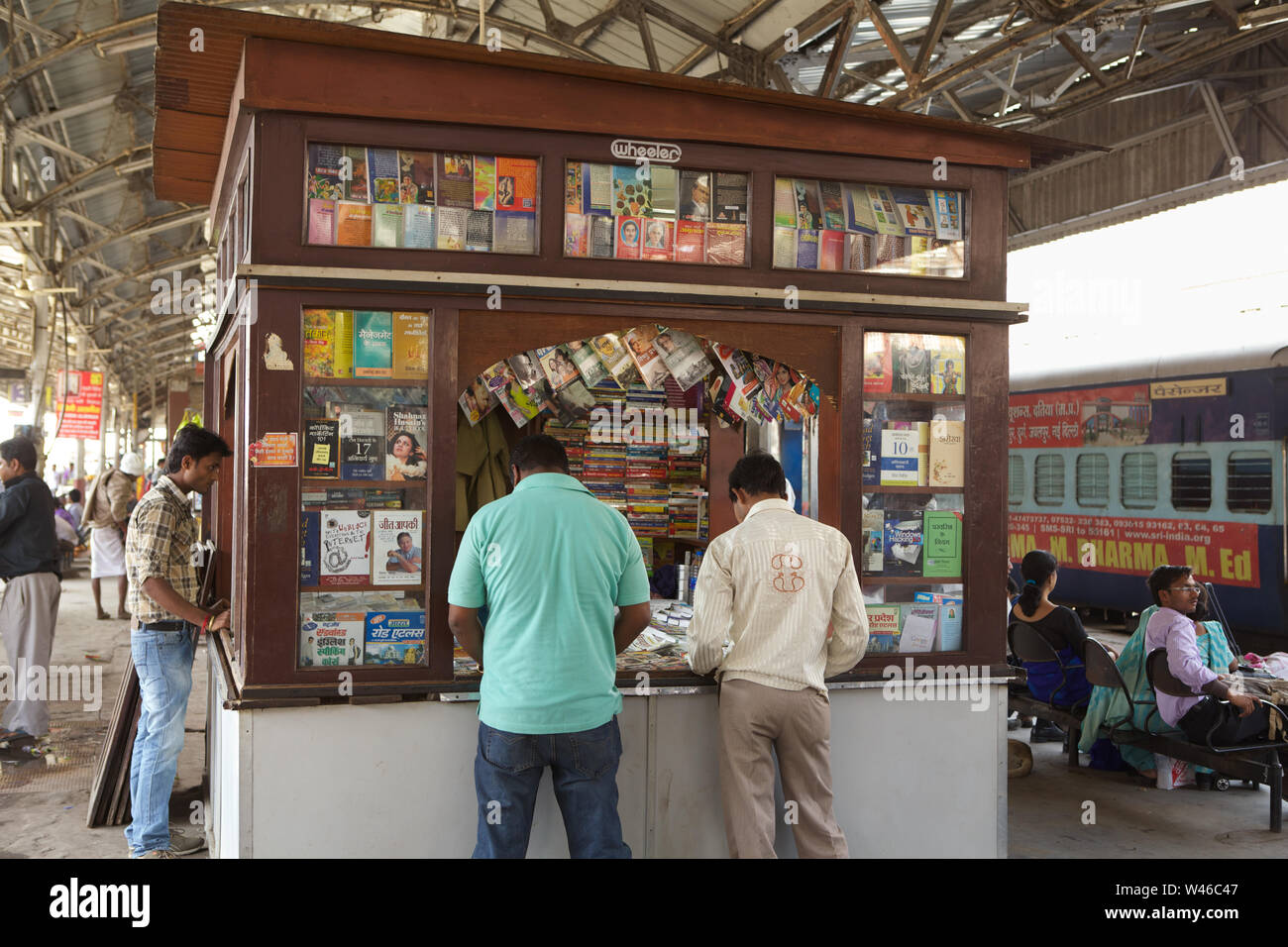 Passengers buying magazine at a book store Stock Photo - Alamy
