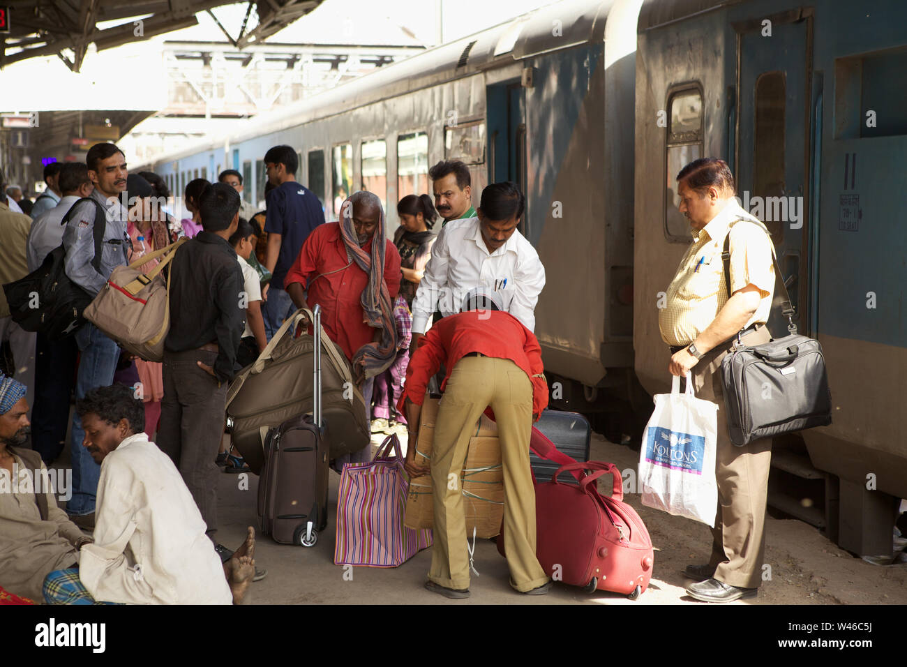 Passengers at railway station Stock Photo - Alamy