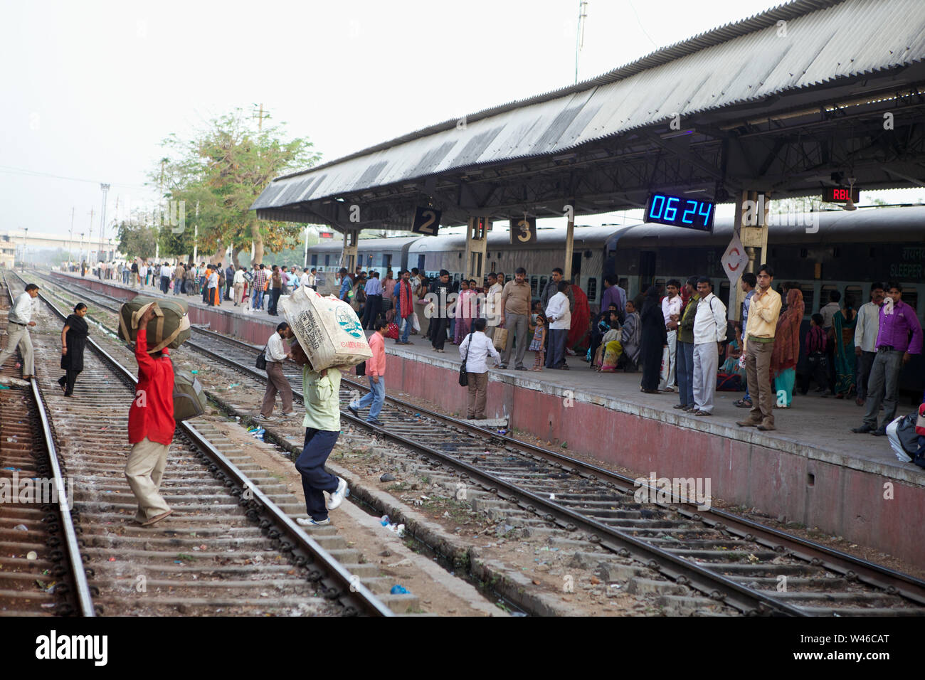 Passengers crossing railway tracks Stock Photo - Alamy