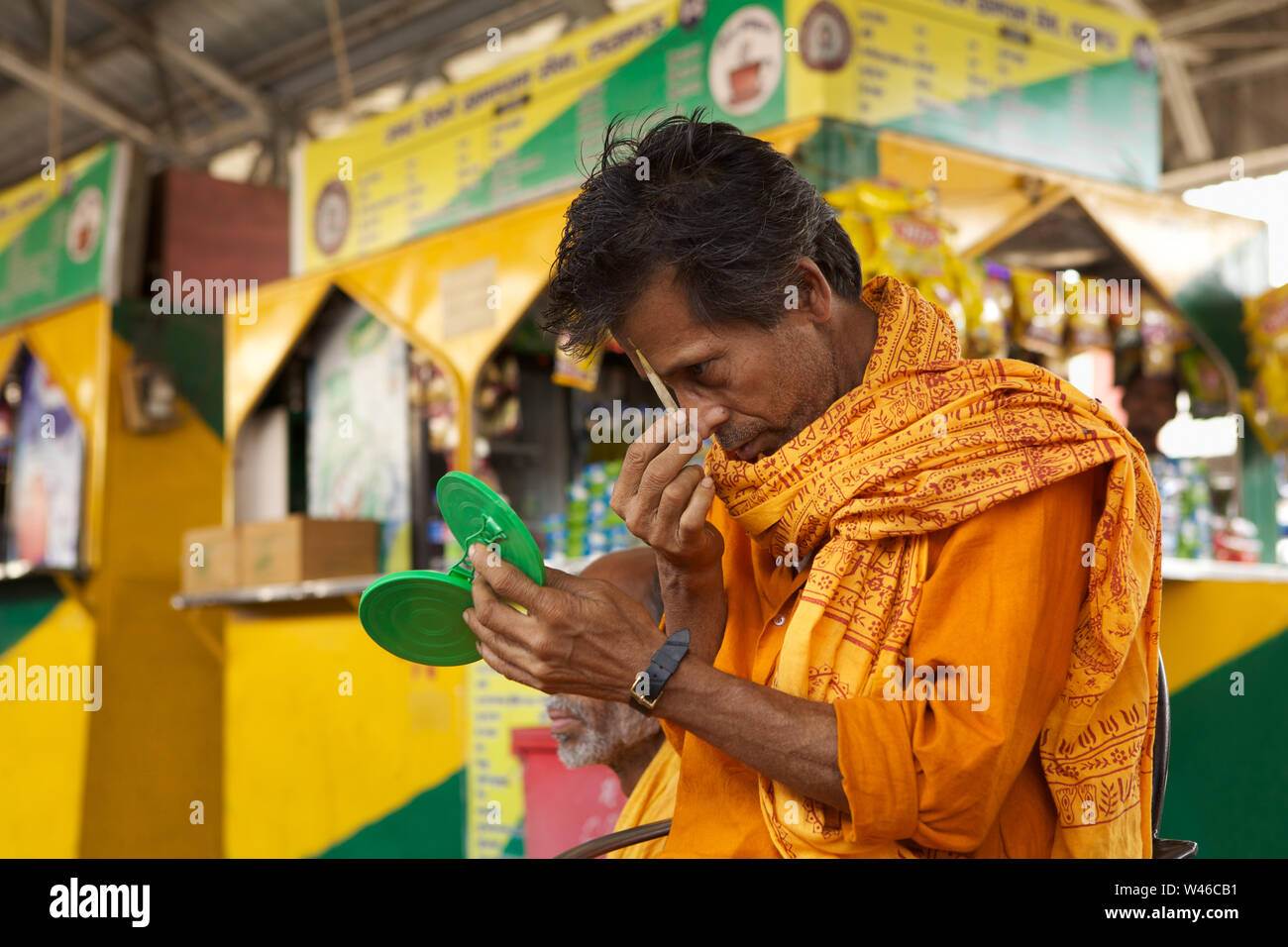 Sadhu applying tika on her forehead at a platform Stock Photo - Alamy