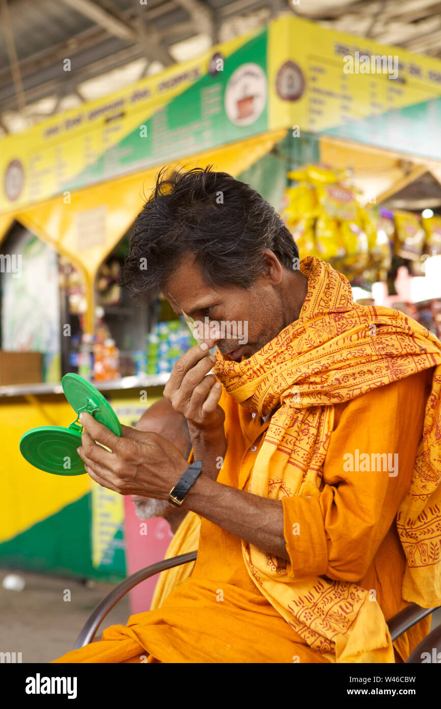 Sadhu applying tika on her forehead at a platform Stock Photo - Alamy