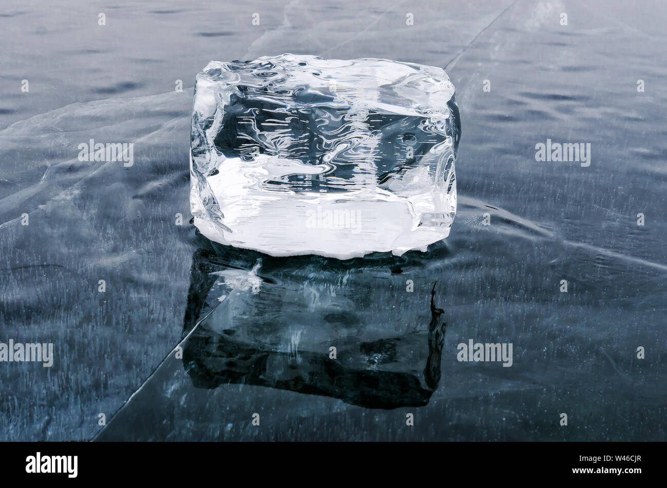 Single Ice Cube with reflection on the lake surface Stock Photo - Alamy