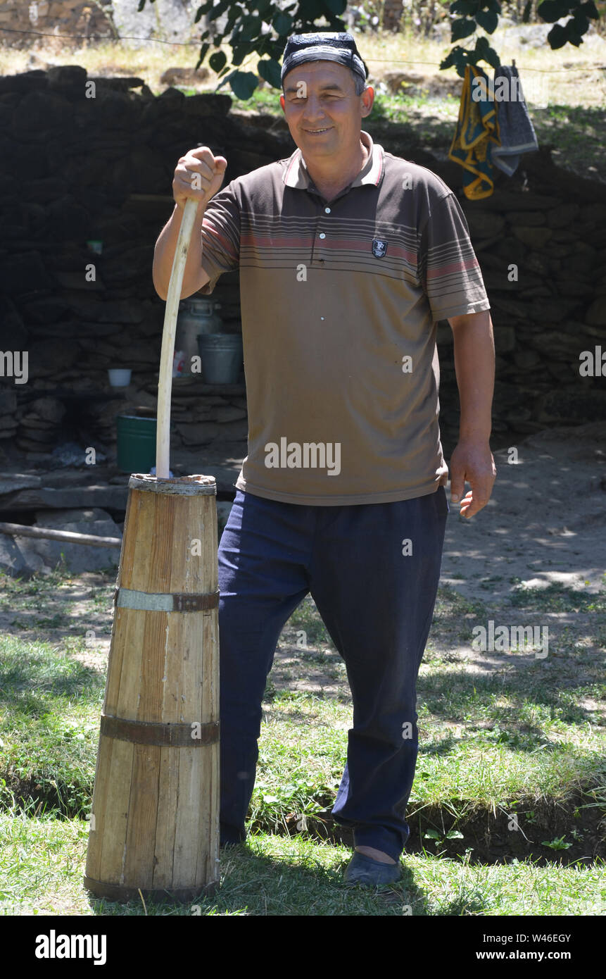 A farmer using a traditional butter churner in the Nuratau mountains ...