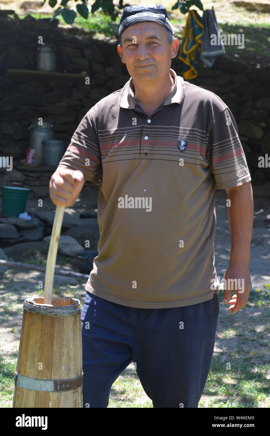 A farmer using a traditional butter churner in the Nuratau mountains ...