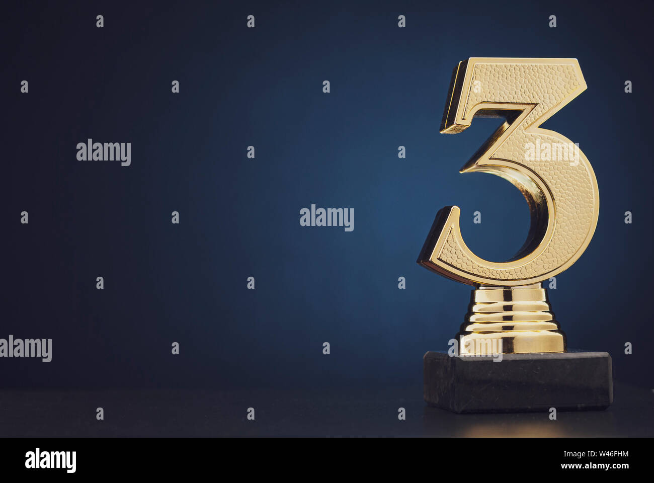 Sharp close up on single isolated gold colored plastic statue of number ...