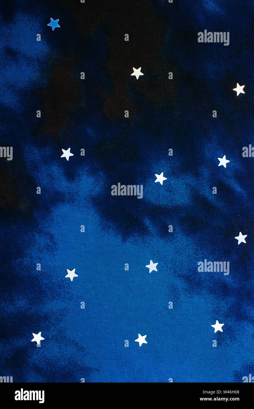 Star shaped bright paper on a blue fabric background Stock Photo - Alamy
